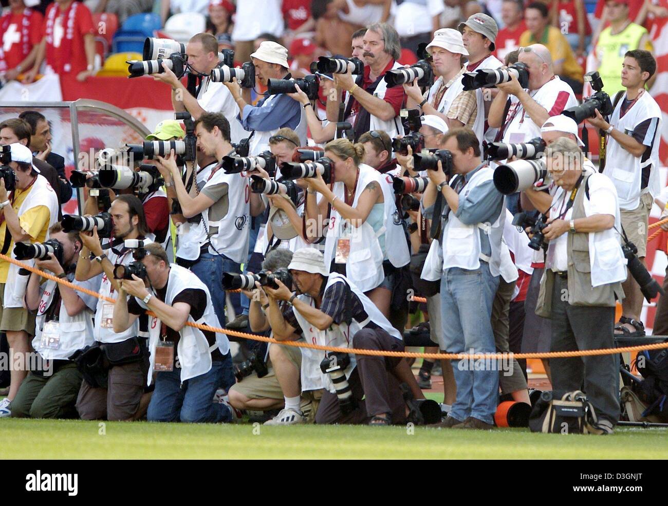 (dpa) - A crowd press photographers stand together during the Euro 2004 ...
