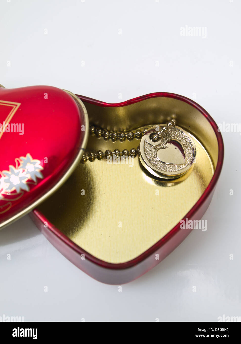 A golden stainless steel heart with a miniature heart key-chain ...