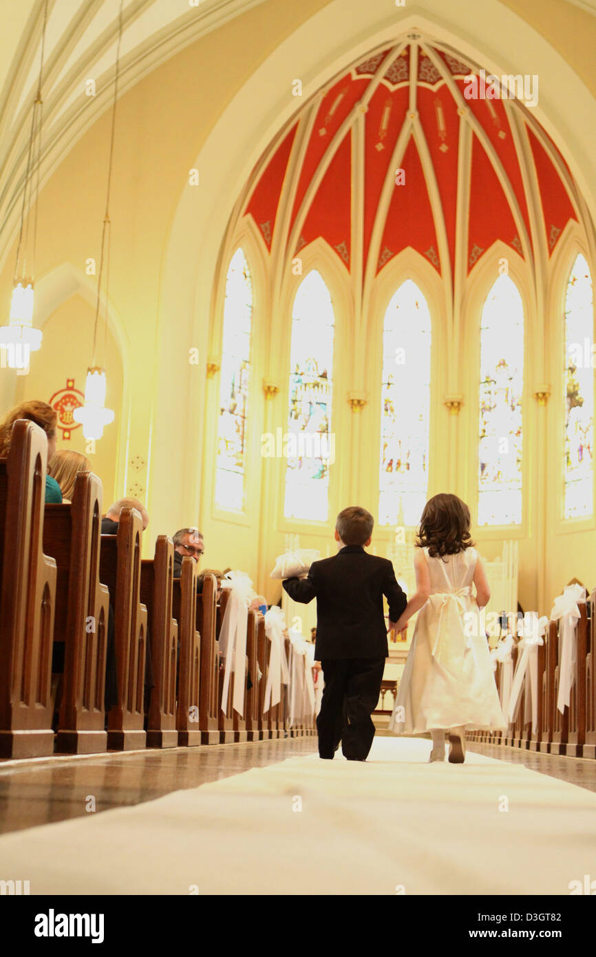 Two little angels holding hands together and walking on the aisle with ...