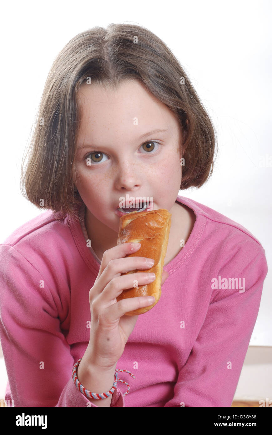 A young girl eating a bun Stock Photo - Alamy