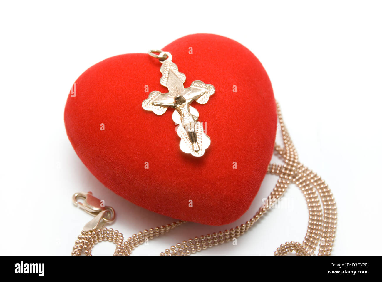 The gold cross with Jesus Christ's image lays on red velvet heart Stock ...