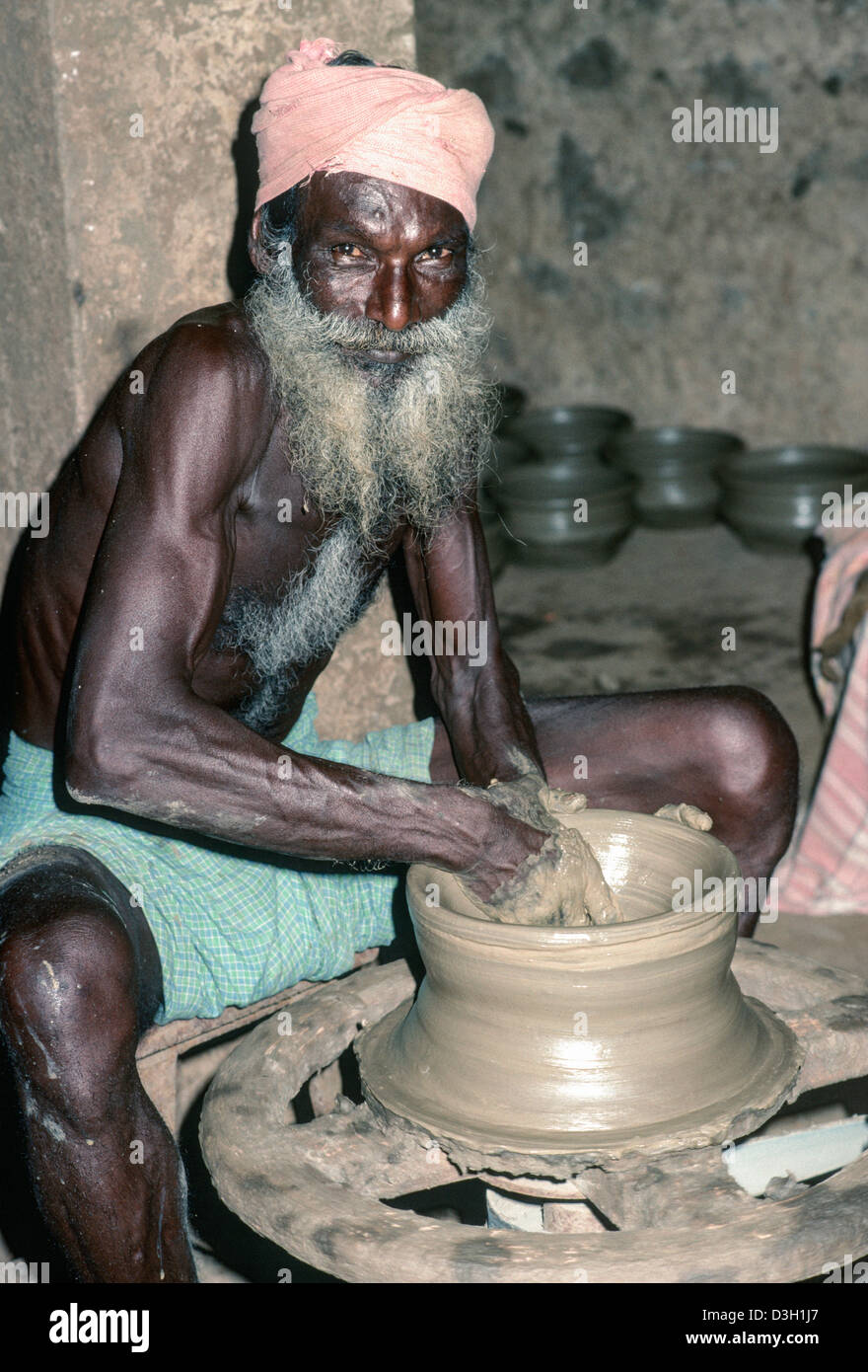Artisanal potter turning a pot on a manual wheel. Tamil Nadu, India ...