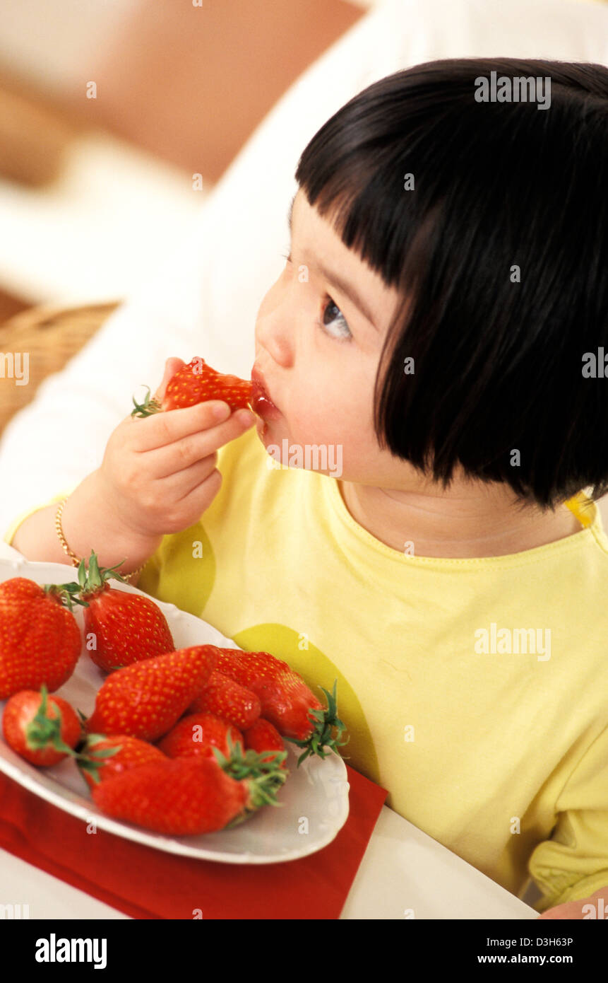 CHILD EATING FRUIT Stock Photo - Alamy