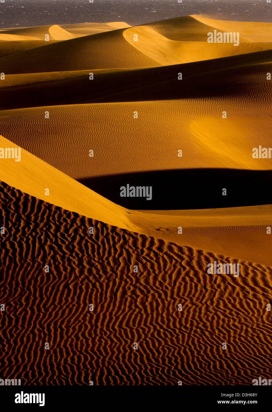 Late night sun shines across the sand dunes of Gran Canaria in the ...