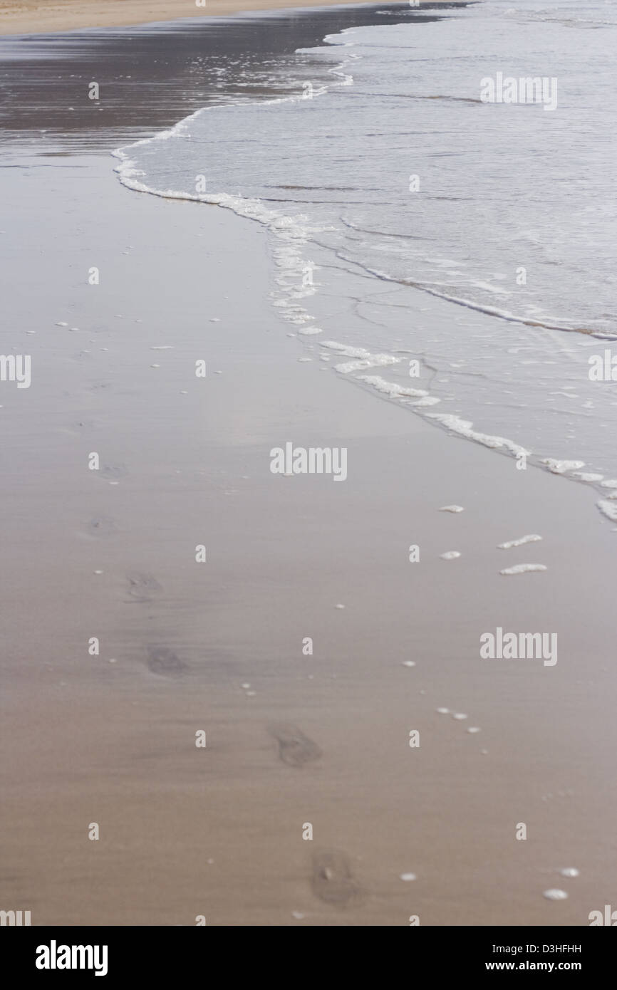 Faded footprints on the seashore Stock Photo - Alamy