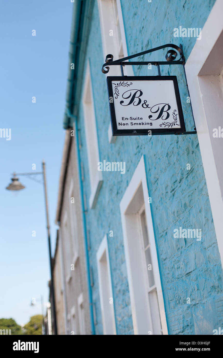 A bed and breakfast sign hung outside a colorfully painted houses in ...