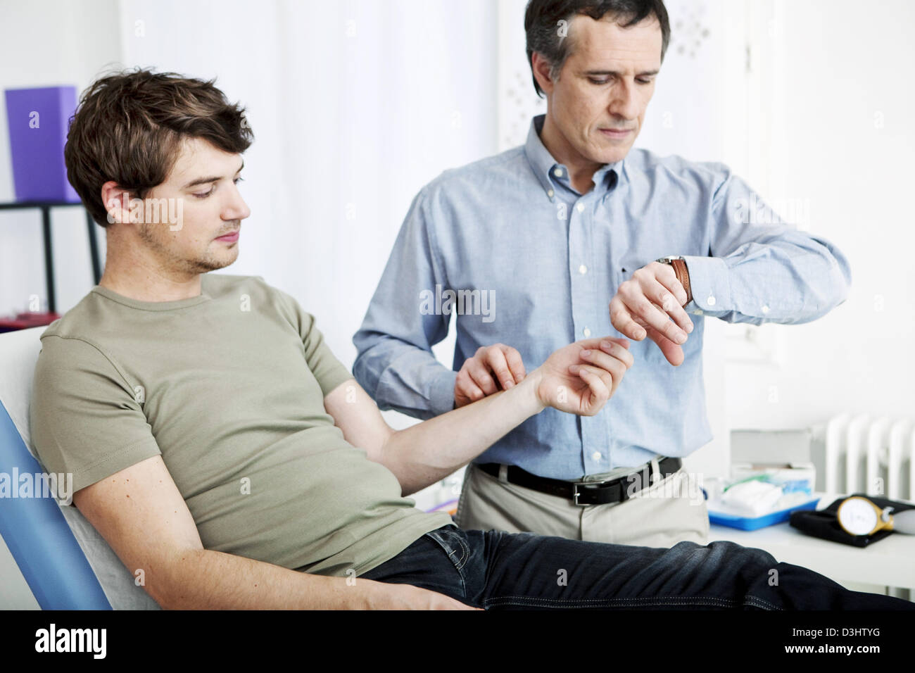TAKING A MAN'S PULSE Stock Photo - Alamy