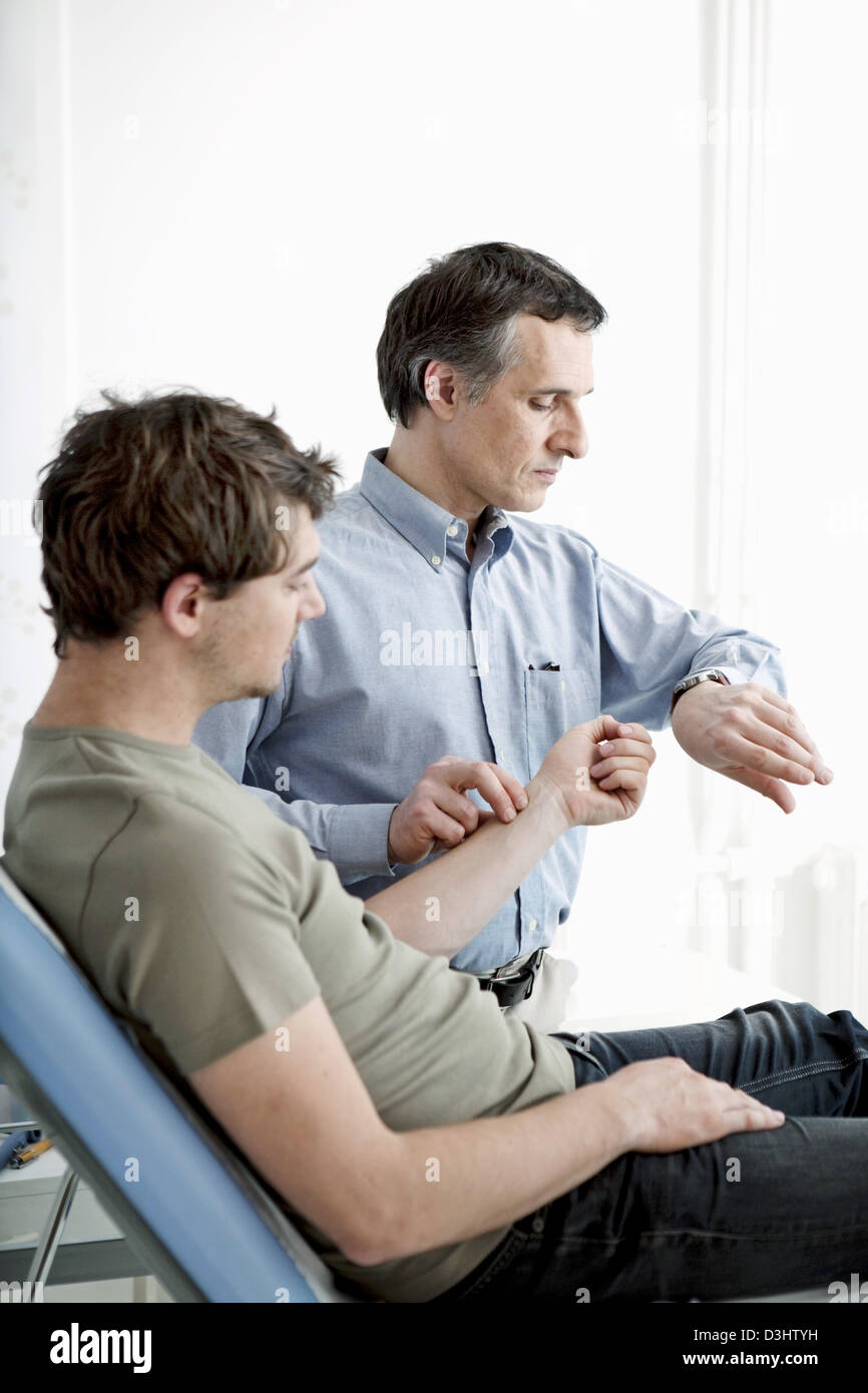 TAKING A MAN'S PULSE Stock Photo - Alamy