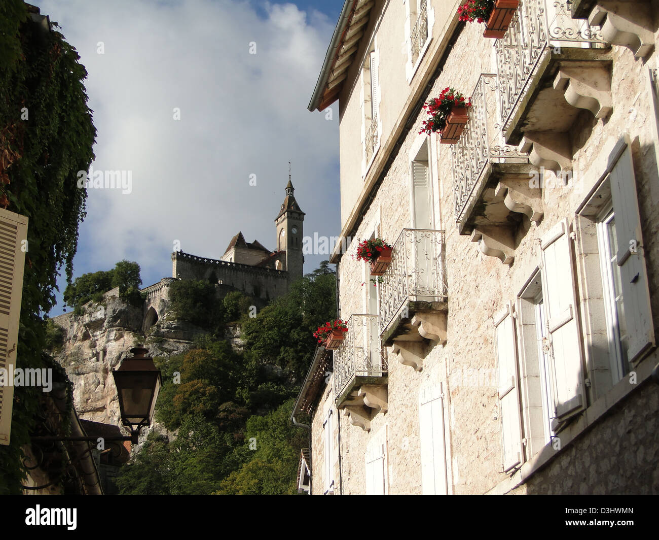Shuttered windows of old hotel with church and citadel in background in ...