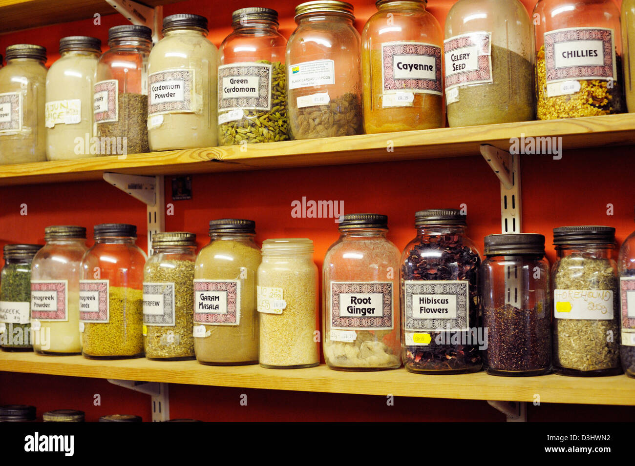 Jars of dried herbs and spices on shelves in a health food shop, Wales Stock Photo - Alamy