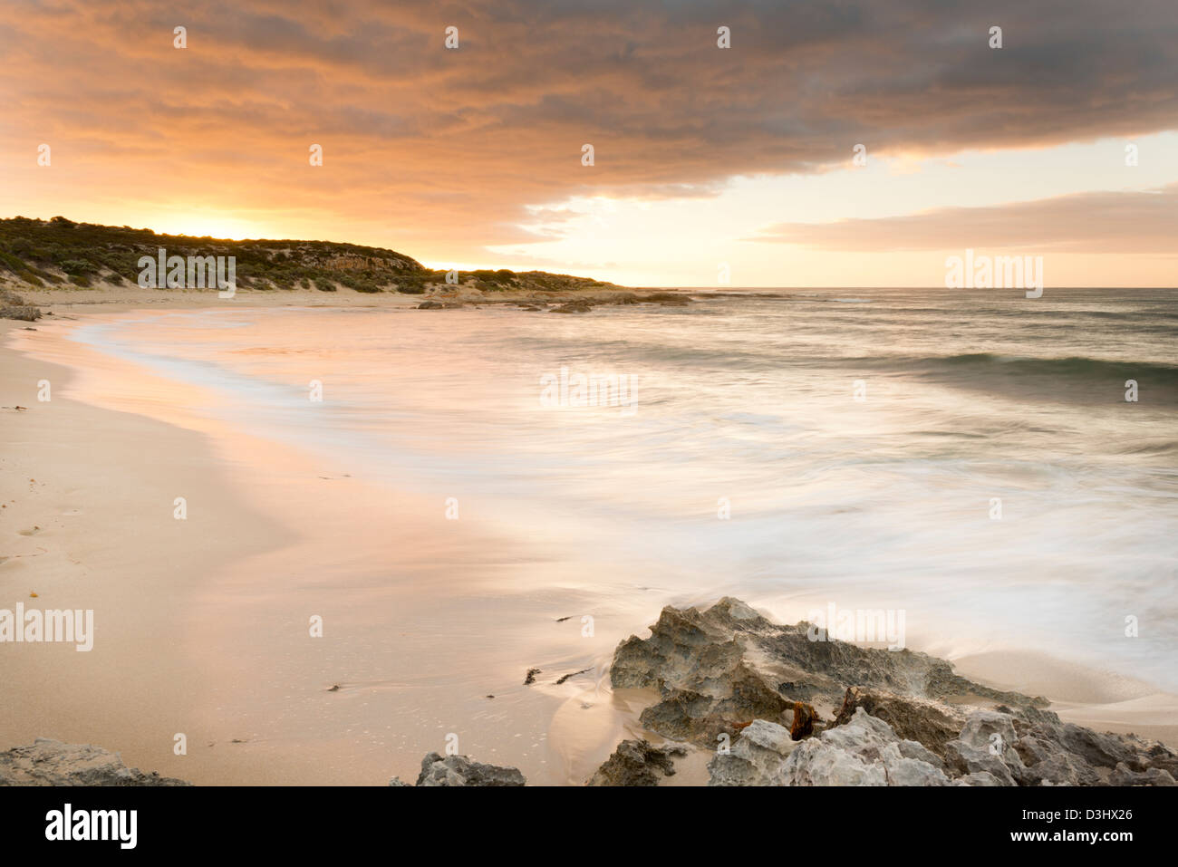 Spectacular sunset over a beach with smooth time-lapse water and sand ...