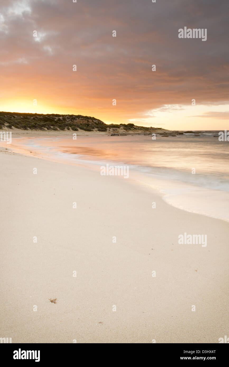 Spectacular sunset over a beach with smooth time-lapse water and sand ...