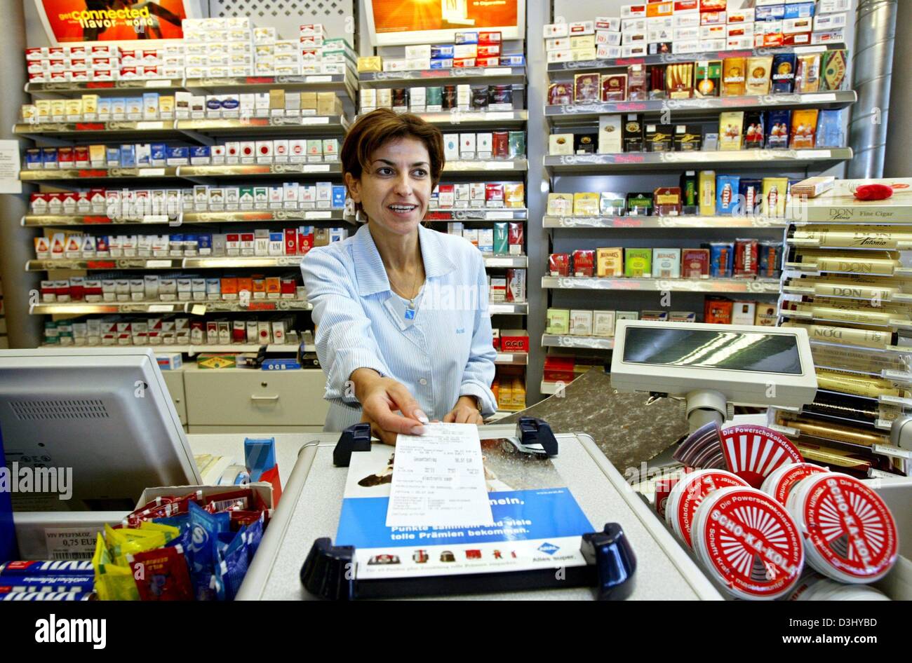 (dpa) - A cashier smiles as she holds a receipt in her hand at a petrol ...