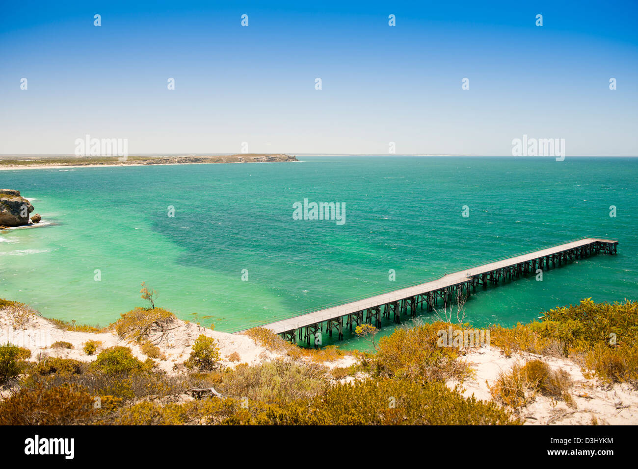 Long wooden jetty stretches out into clear water at Stenhouse Bay ...