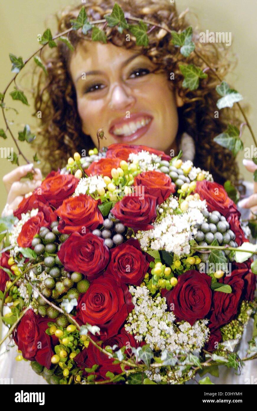 Model Melanie smiles as she presents a bunch of protea flowers (protea ...