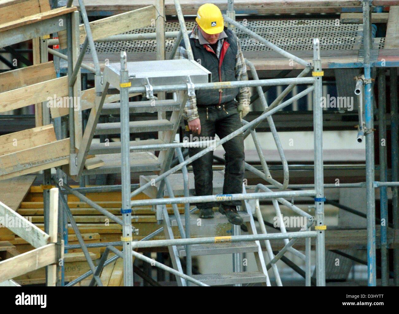 (dpa) - A construction worker walks down the stairs of a scaffolding in ...
