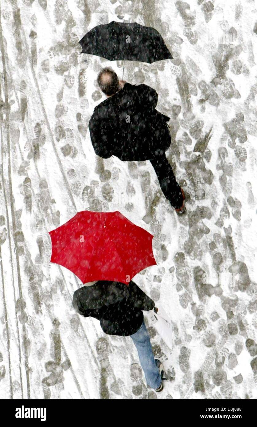 (dpa) - Passers-by walking over the snow-covered pavement, seen from ...