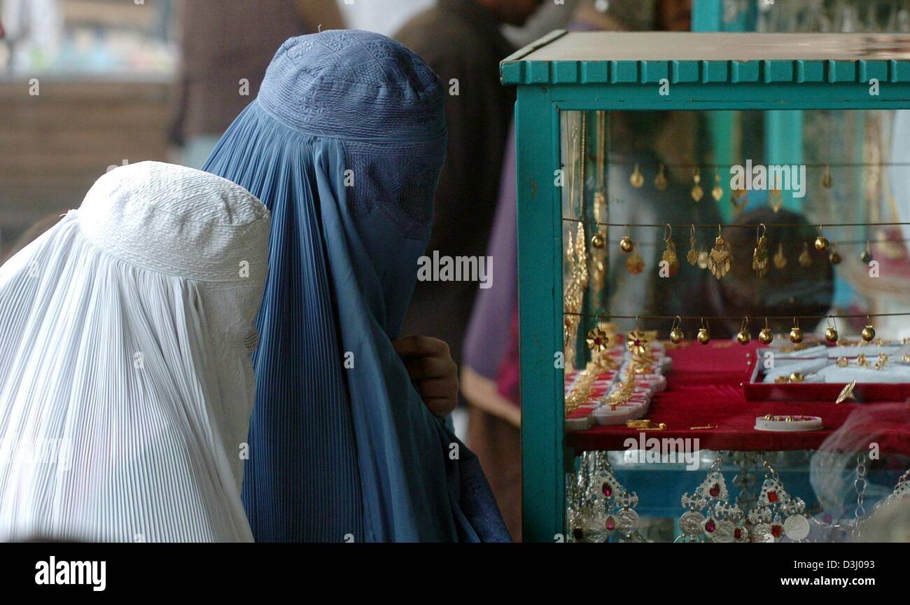 (dpa) - Women clad with the traditional burka look at the objects ...