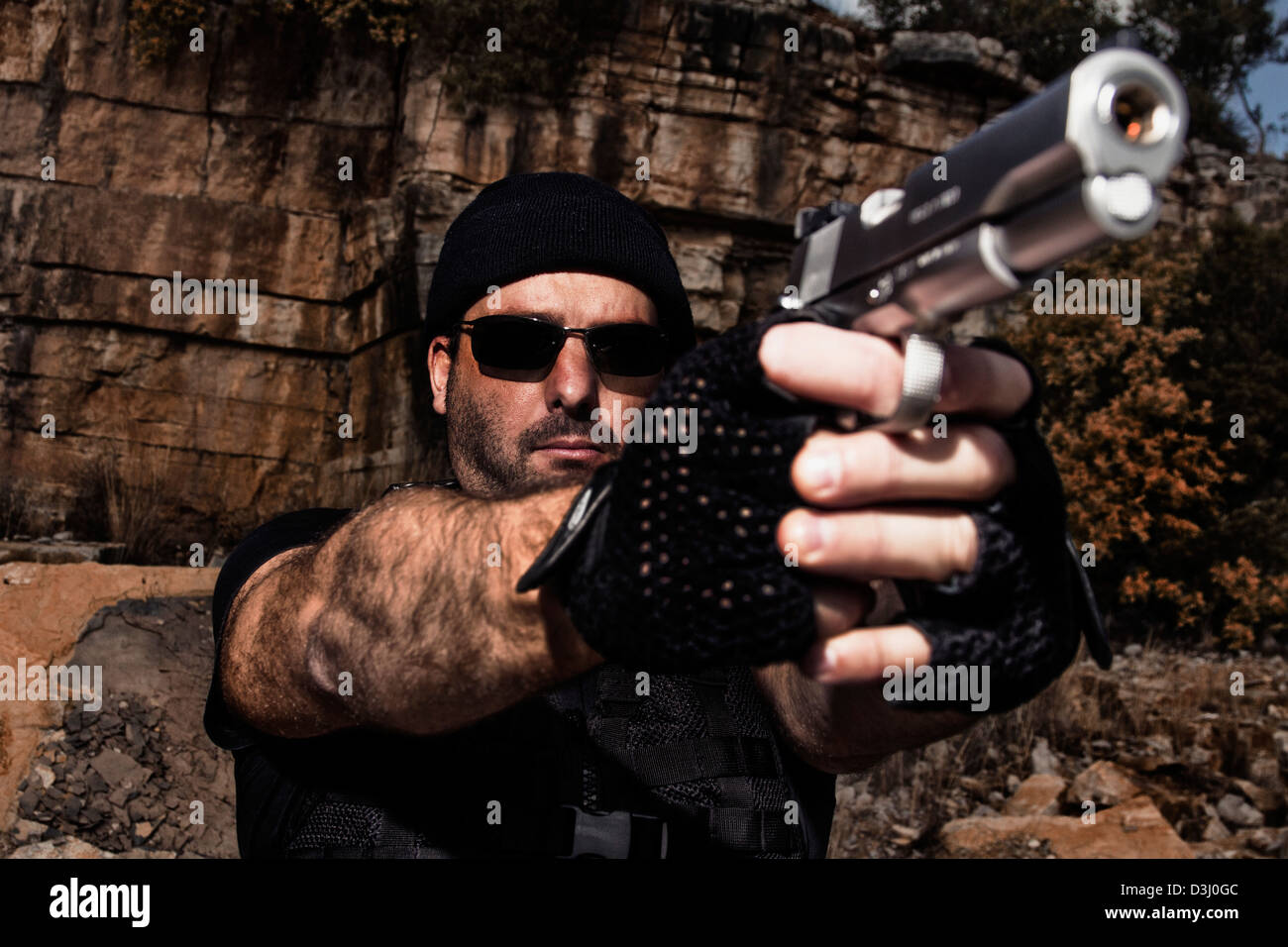 View of a man with dark shades pointing a gun to the camera Stock Photo ...