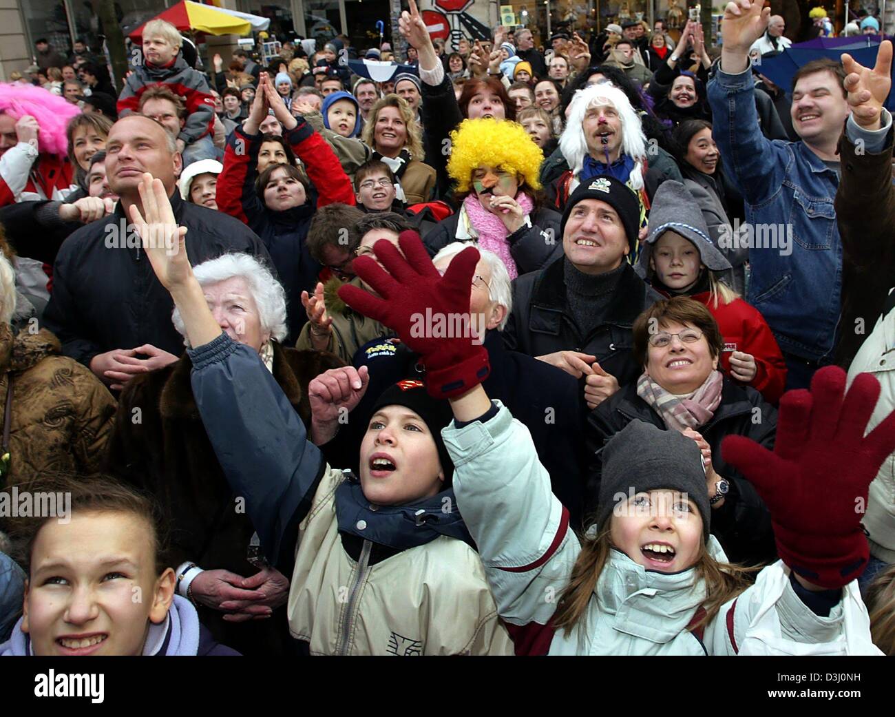(dpa) - Onlookers of the Carnival parade try to catch candies and ...