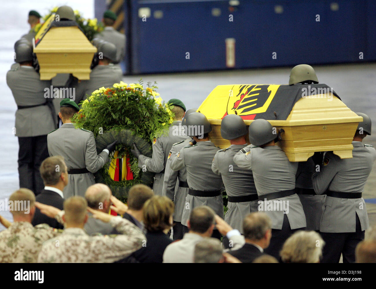 (dpa) - German Bundeswehr soldiers carry the coffins of the two German ...