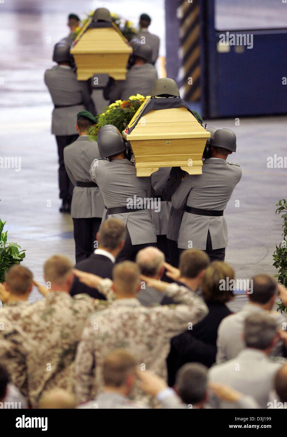 (dpa) - German Bundeswehr soldiers carry the coffins of the two German ...