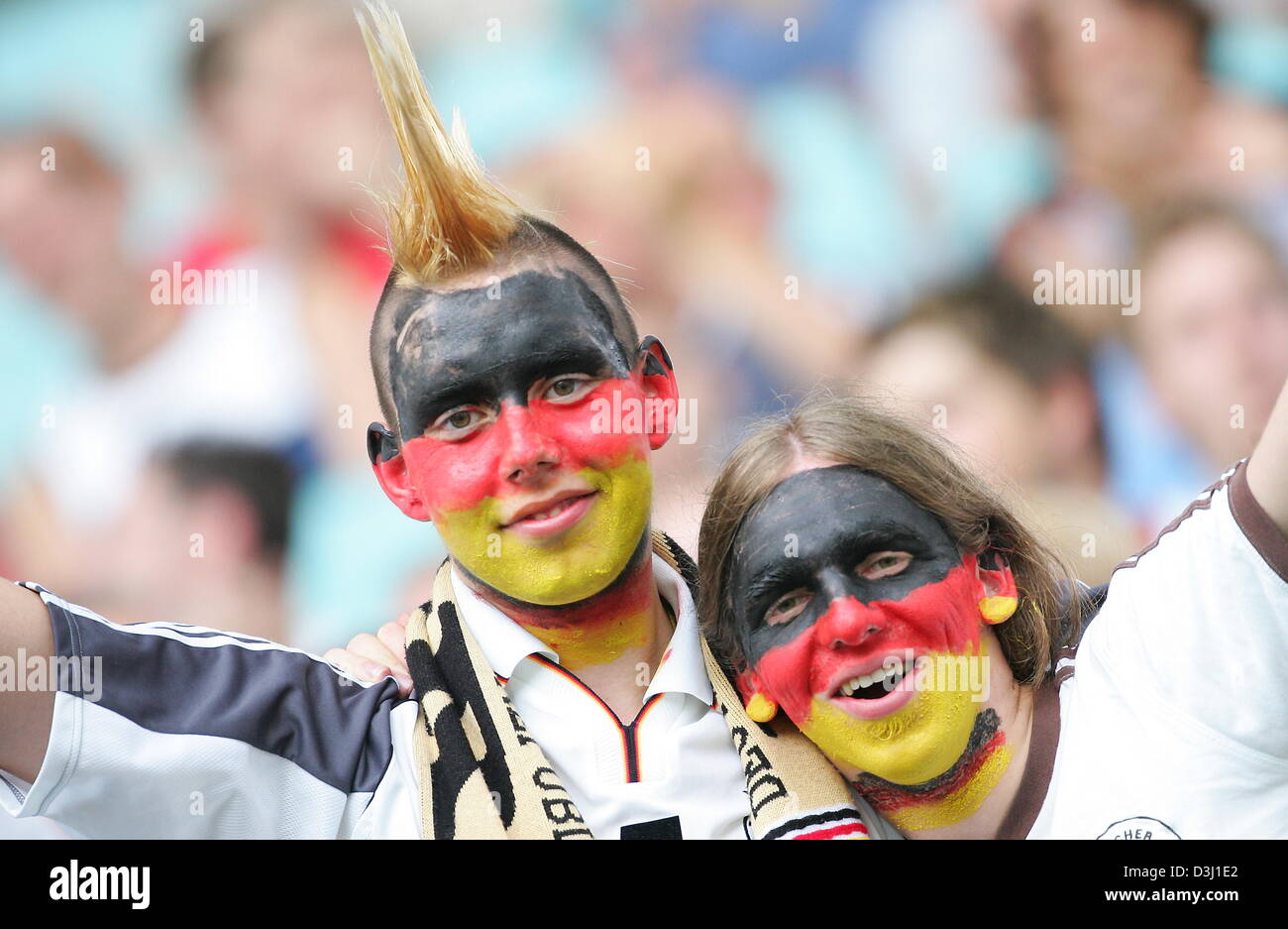 (dpa) - German soccer fans wear the their national colours painted on ...