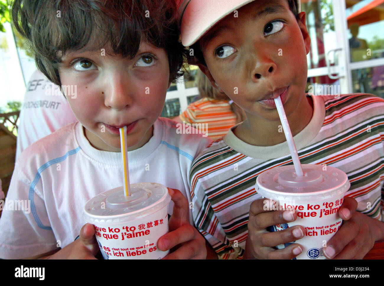 (dpa) - Two boys drink Coca Cola at a fast food restaurant near ...