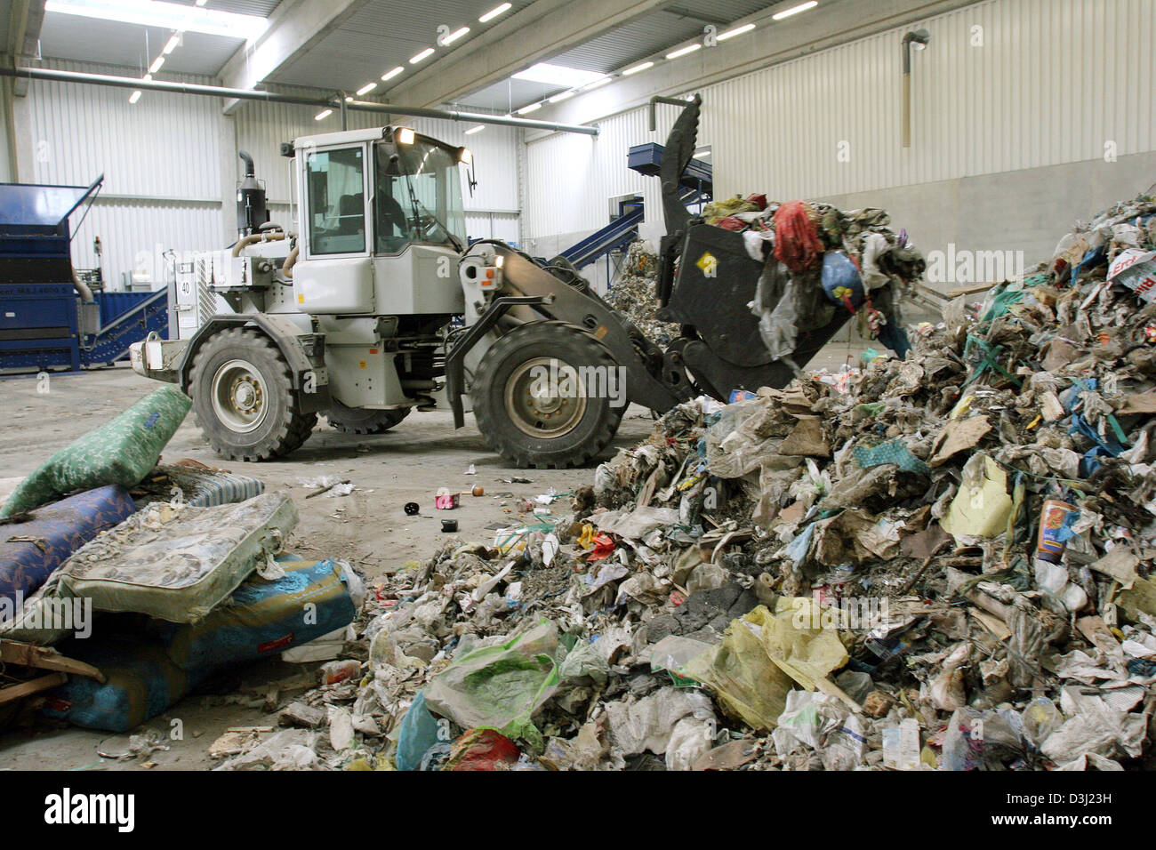 (dpa) - A wheel loader shovels waste in a warehouse at the sorting ...
