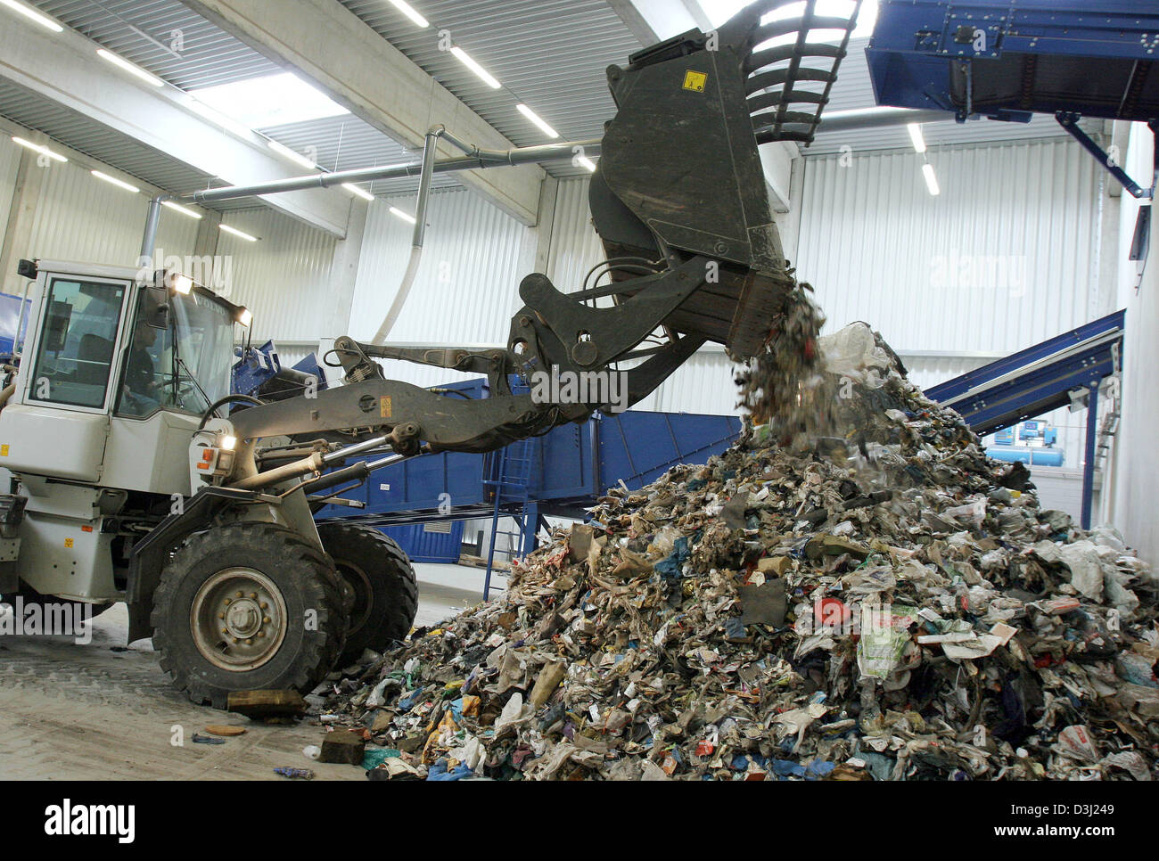 (dpa) - A wheel loader shovels waste in a warehouse at the sorting ...