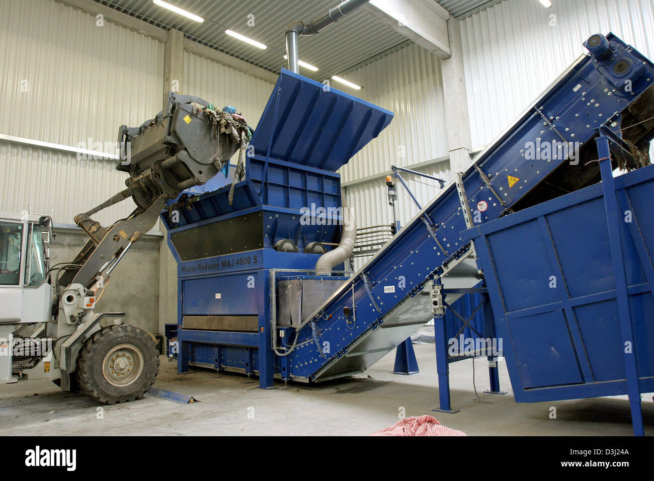 (dpa) - A wheel loader shovels waste in a warehouse at the sorting ...