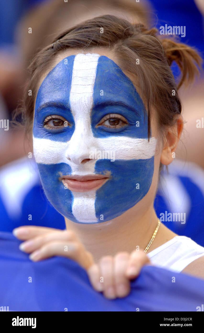 (dpa) - A Greek supporter wearing the Greek national colours painted on ...