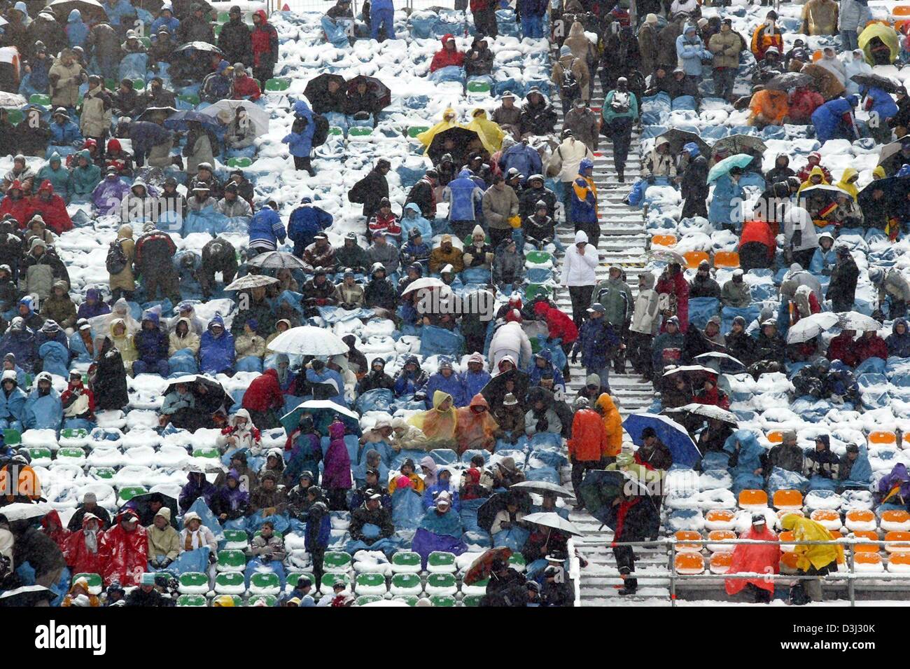 (dpa) - Spectators at the World Cup skijumping event brave the snow as ...