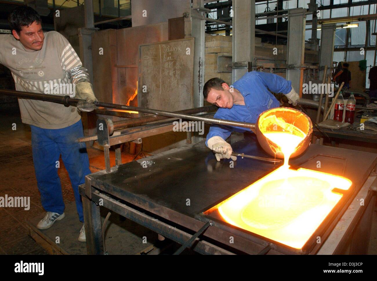 (dpa) - Two workers cast red-hot fluid glass to produce a table top, at ...