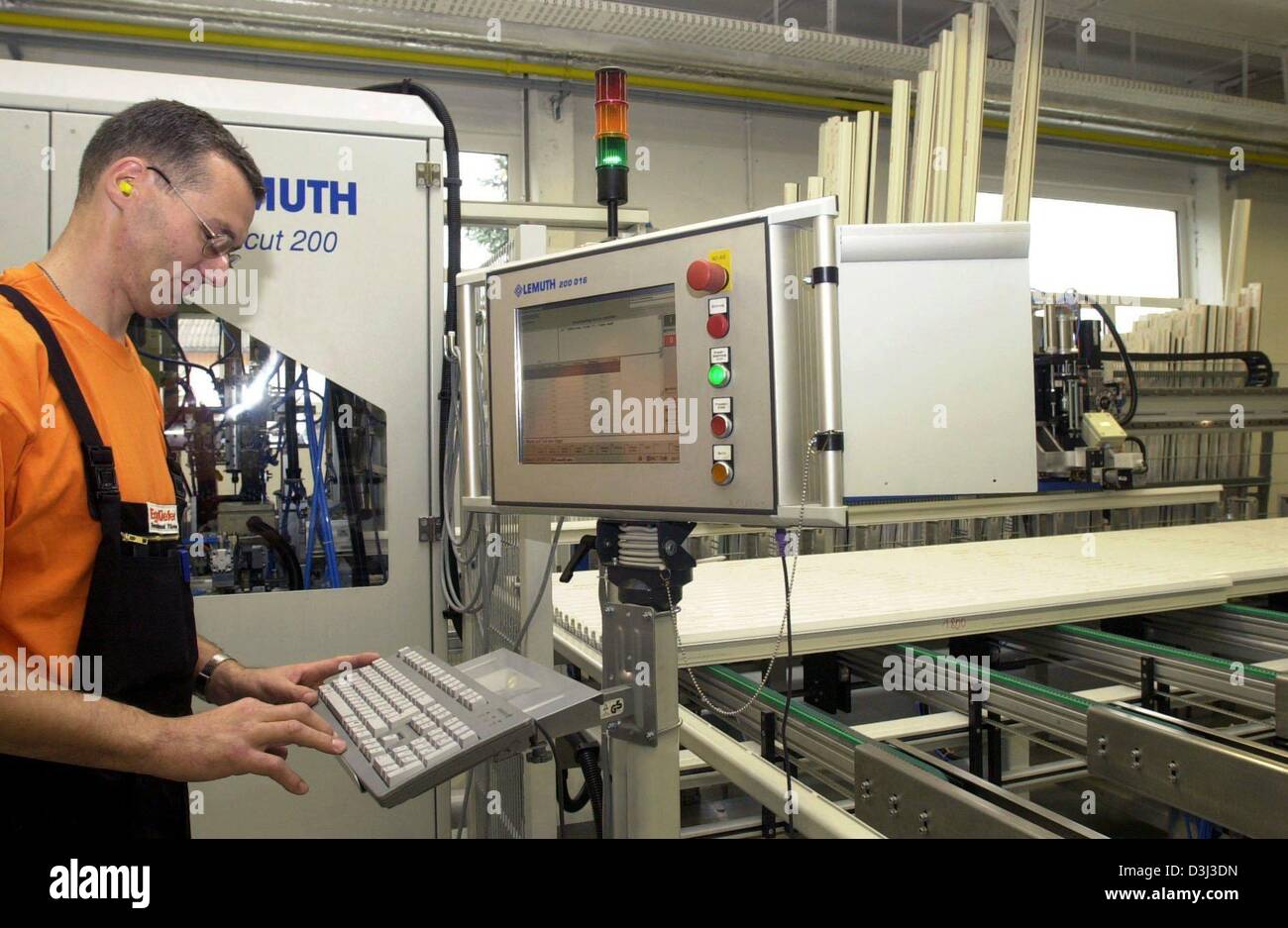 (dpa) - An employee controls the production of a window frame from a ...