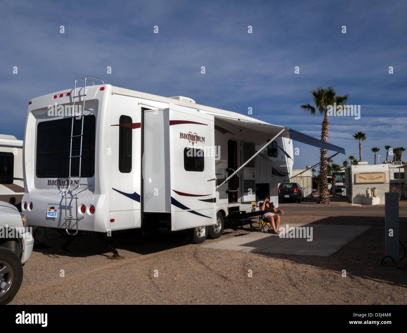 Woman sitting outside fifth-wheel RV trailer at Indian Skies RV Park ...
