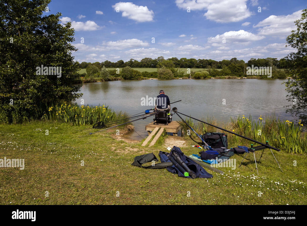 Fisherman sitting fishing at lake with a huge array of fishing ...