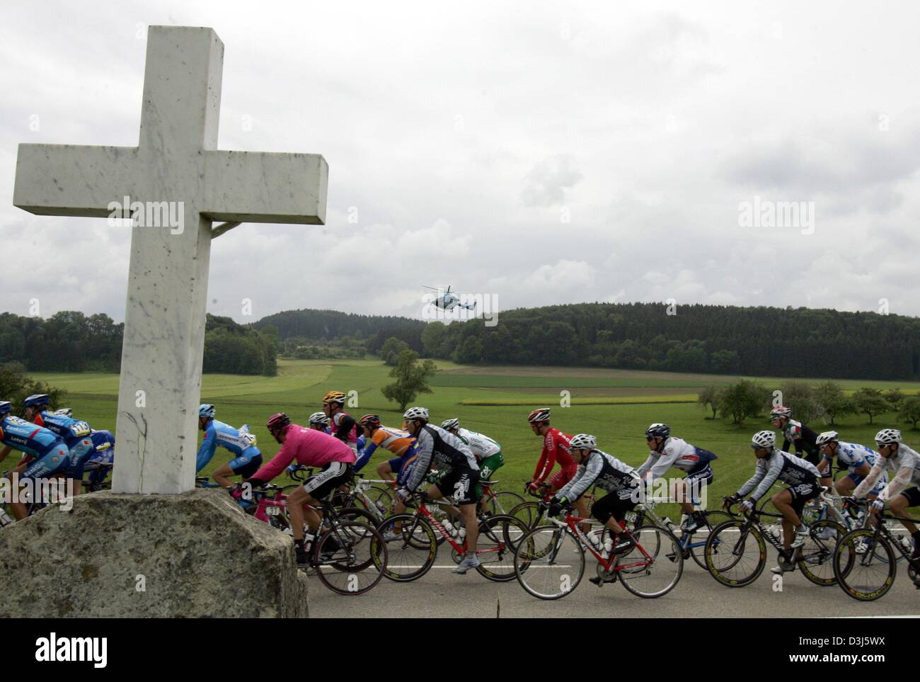 (dpa) - Cyclists pass a cross during the second stage of the Tour of ...