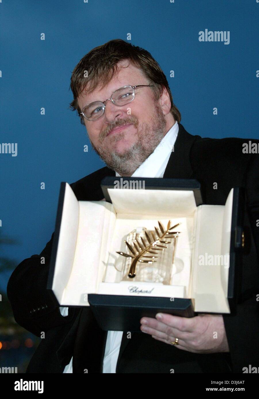 (dpa) - US film director Michael Moore shows his Golden Palm Award ...