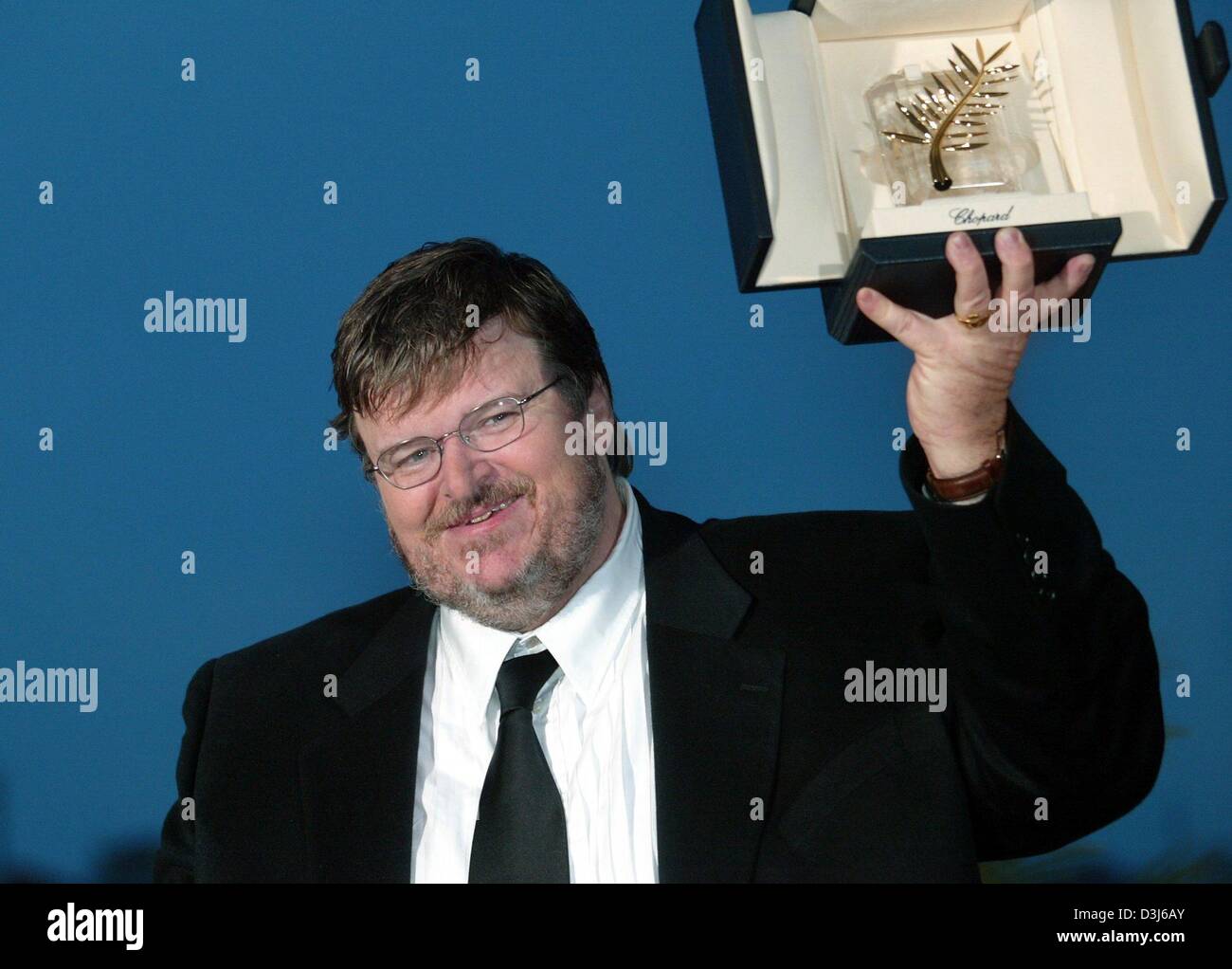 (dpa) - US film director Michael Moore shows his Golden Palm Award ...