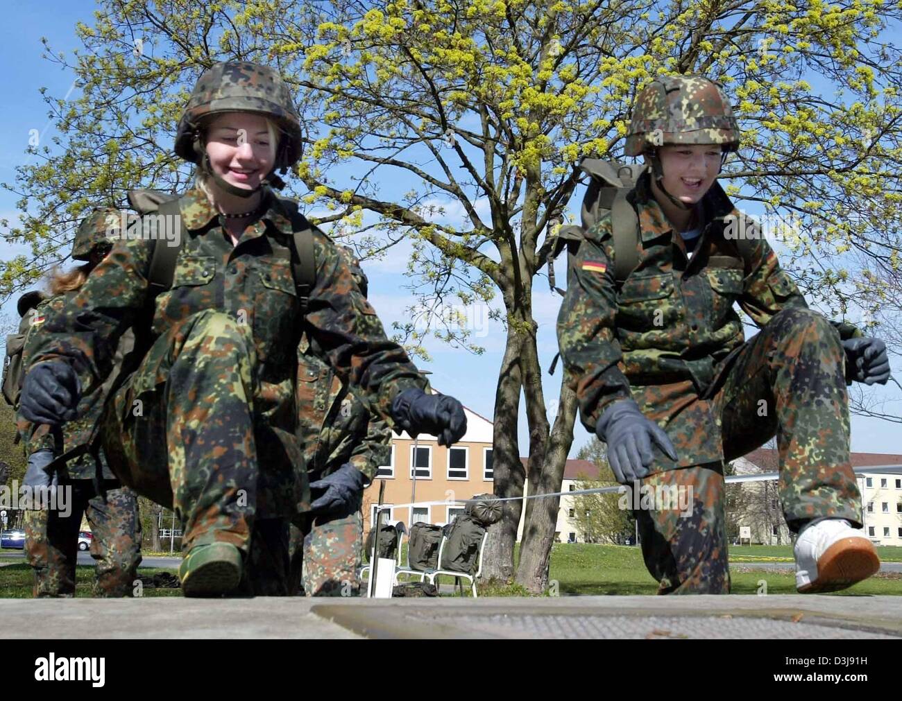 (dpa) - Two girls dressed in combat uniform overcome an obstacle during ...