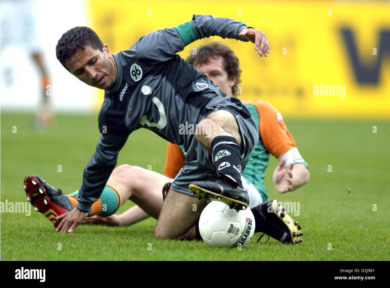(dpa) - Bremen's midfielder Frank Baumann (back) attacks Hanover's ...