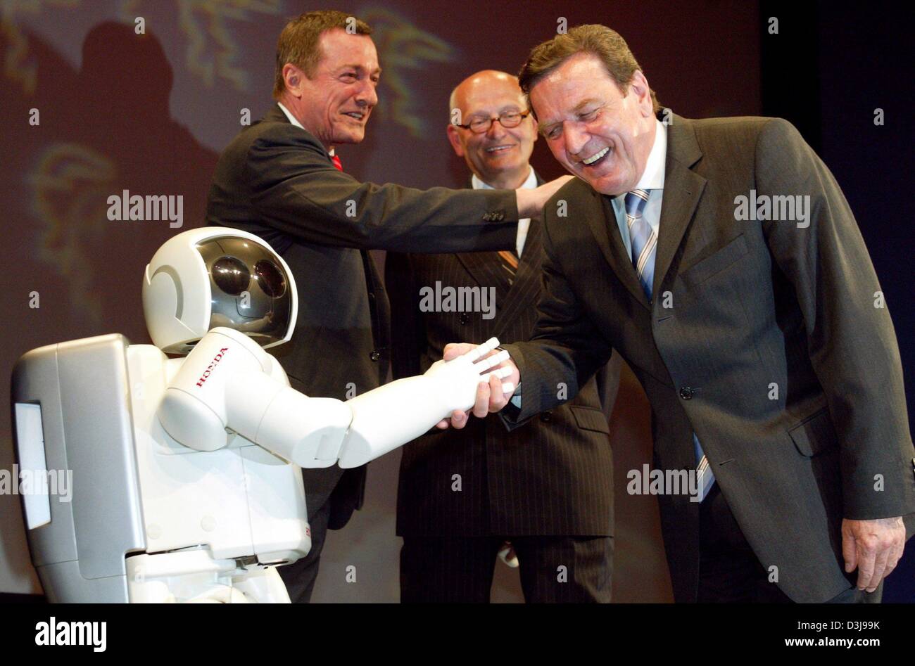 (dpa) - German Chancellor Gerhard Schroeder (R) smiles as he gets a ...