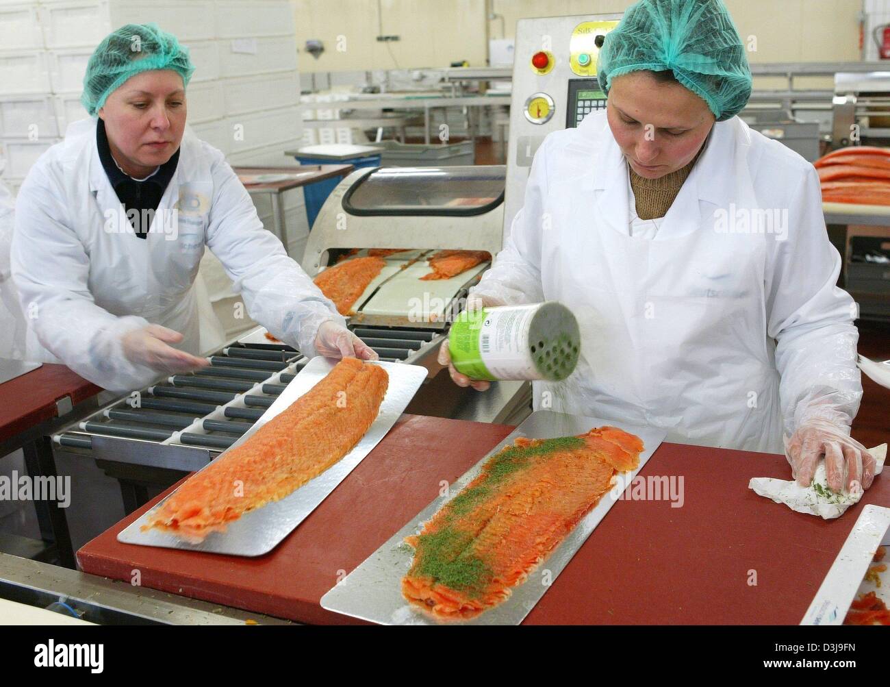 (dpa) - Two employees of 'Deutsche See', wear gloves and protectvie ...