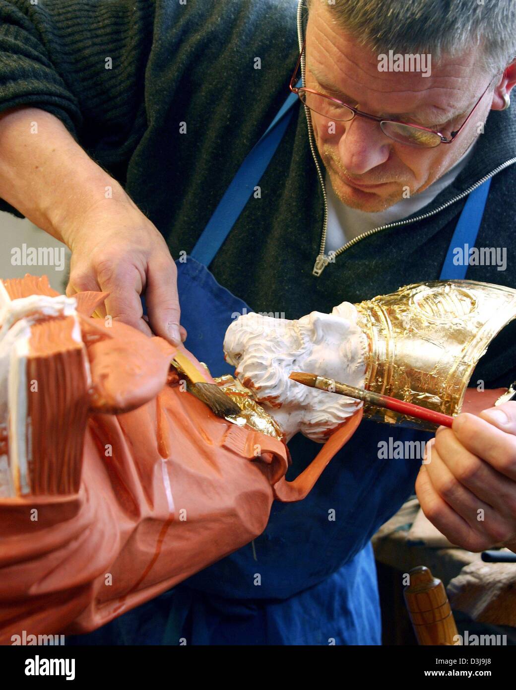 (dpa) - A German wood carver works on a religious figurine in ...