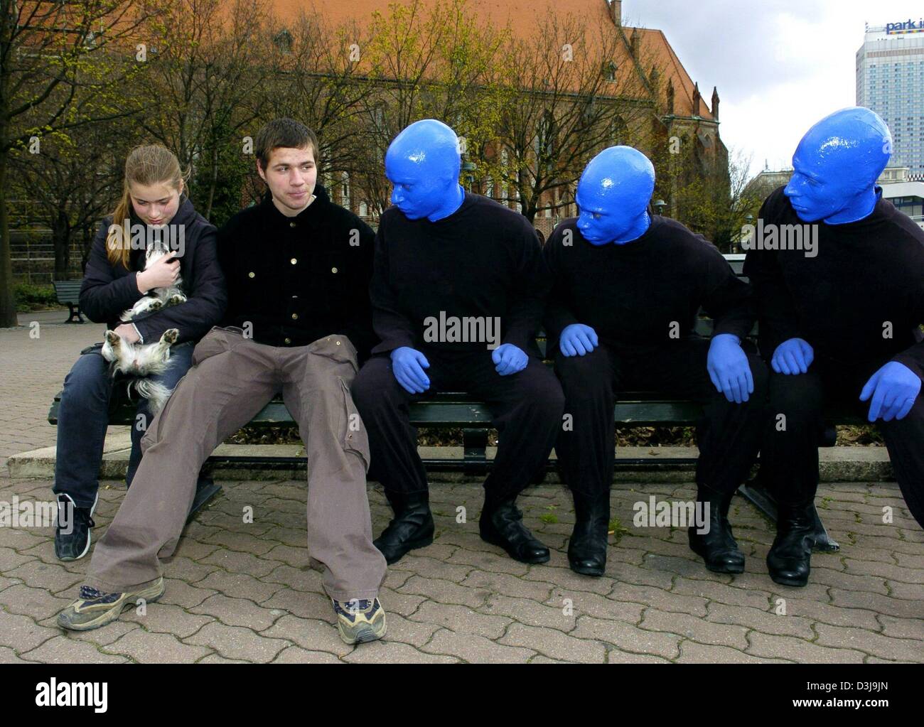 (dpa) - Three members of the Blue Man Group look at two young people ...