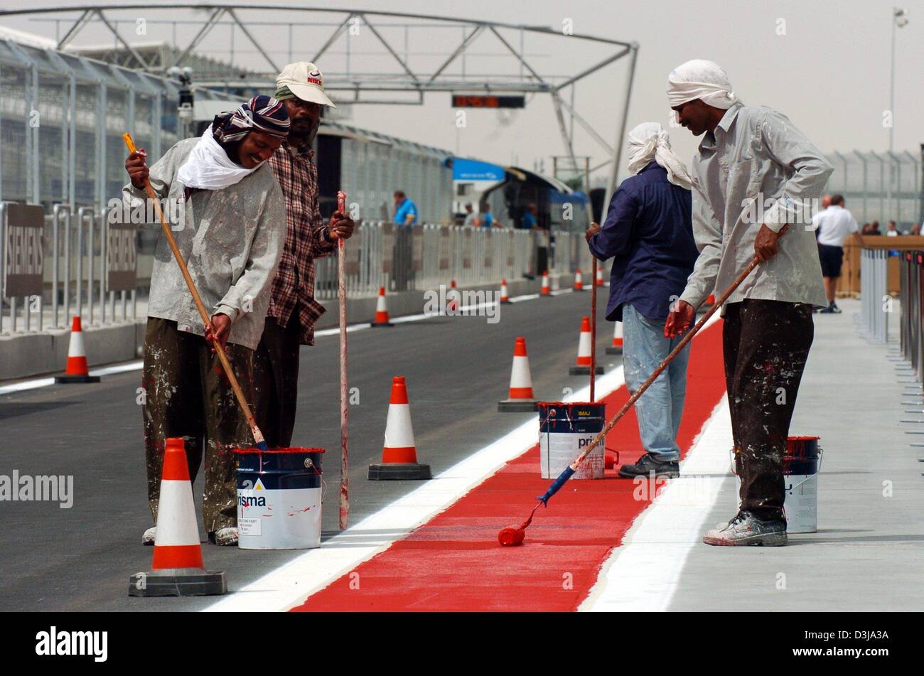 (dpa) Bahraini workers paint the zoning lines in the pit lane of the ...