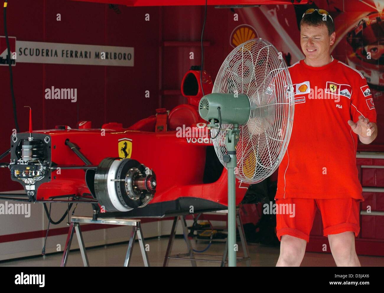 (dpa) A Ferrari mechanic enjoys the benefit of a fan in the Ferrari-box ...