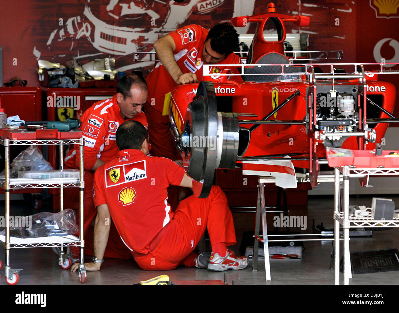 (dpa) - Mechanics of Ferrari team work on the racing car of German ...