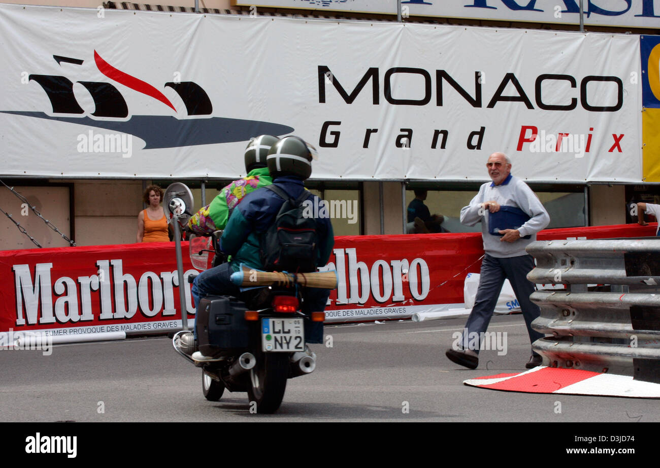 (dpa) - A man crosses the street while a motorbike drives into the ...